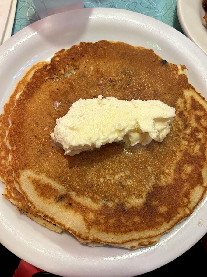 Golden perfection on a plate! This pancake achieves that mythical balance&mdash;crispy edges giving way to cloud-like centers, topped with a generous pat of melting butter.