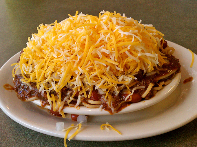 Behold the legendary three-way: a mountain of finely shredded cheddar blanketing spiced chili atop spaghetti. Resistance is futile, napkins are mandatory.