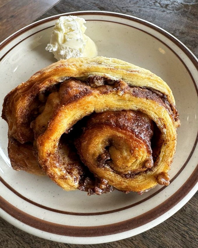 The legendary cinnamon roll in its natural habitat. That spiral of cinnamon-sugar perfection is worth every minute in line.