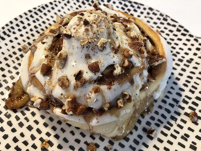 This isn't just any cinnamon roll&mdash;it's a pillowy spiral of perfection topped with nuts and a drizzle that'll make you weak in the knees.