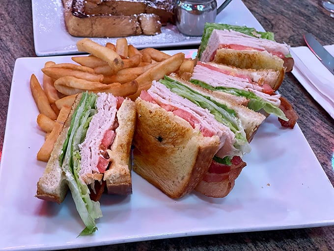 This isn't just a club sandwich &ndash; it's architectural perfection. Three stories of toasted goodness that makes vertical eating an Olympic sport.