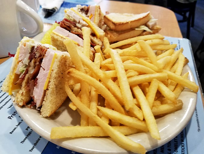 The legendary club sandwich in its natural habitat, surrounded by golden fries. Architecture students should study how this triple-decker maintains structural integrity despite its generous fillings.