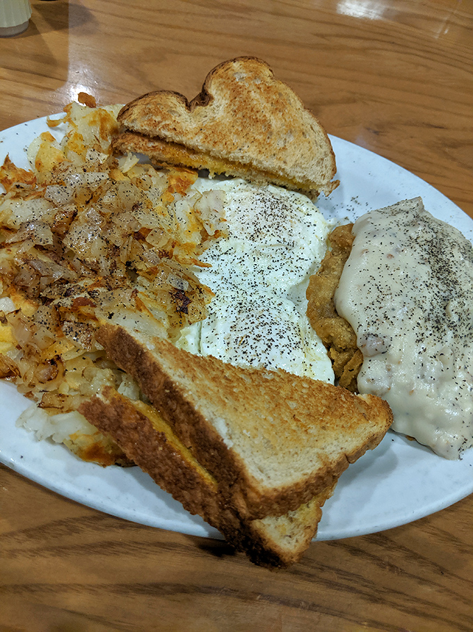 Breakfast perfection on a plate: golden hash browns, perfectly peppered eggs, and toast ready to soak up every last bit of yolk.