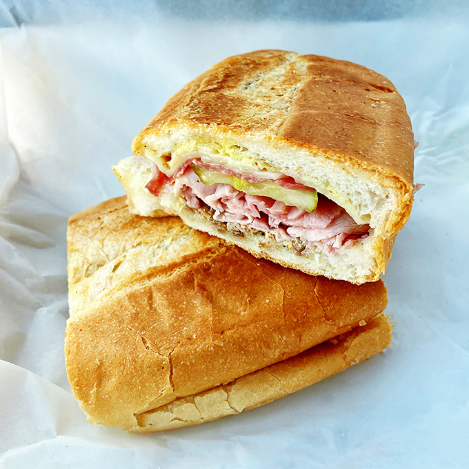 Behold the Cuban sandwich in its natural habitat! Layers of ham, pork, and cheese pressed between La Segunda's legendary bread create Tampa's most perfect portable meal.