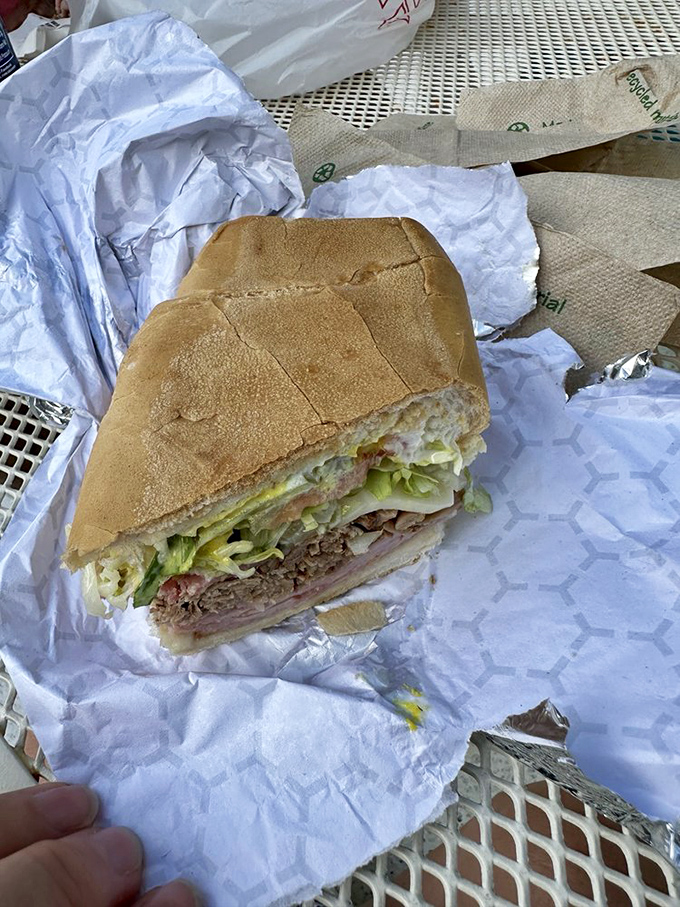 This isn't just a sandwich; it's architecture. Layers of meat, cheese, and pickles create a perfect structural integrity that somehow maintains its dignity even mid-bite.