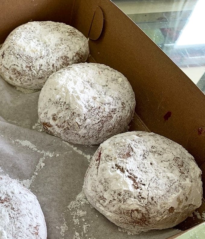 Powdered sugar donuts nestled in their box like snowballs waiting for a winter food fight. One bite and you'll be wearing the evidence of your indulgence.