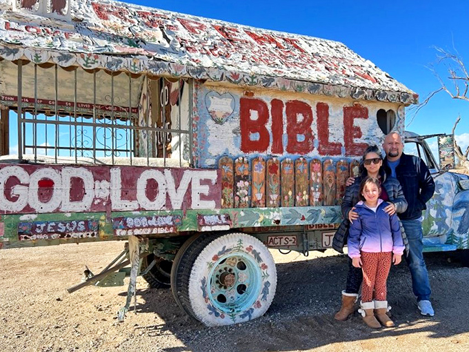 A colorful Bible truck stands sentinel in the harsh desert landscape, its weathered frame and vibrant paint telling stories of faith and perseverance.