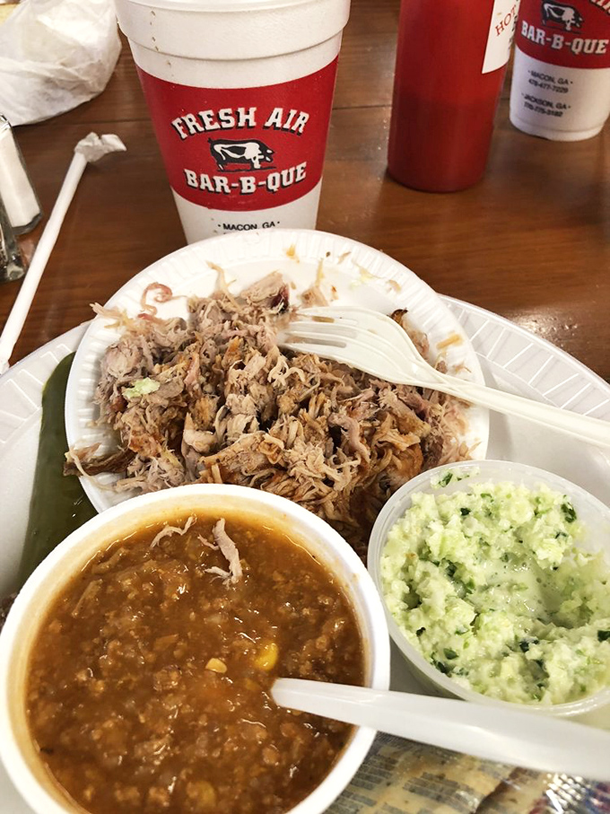 BBQ trinity: Chopped pork glistening with sauce, Brunswick stew bubbling with promise, and coleslaw offering the perfect cool counterpoint.