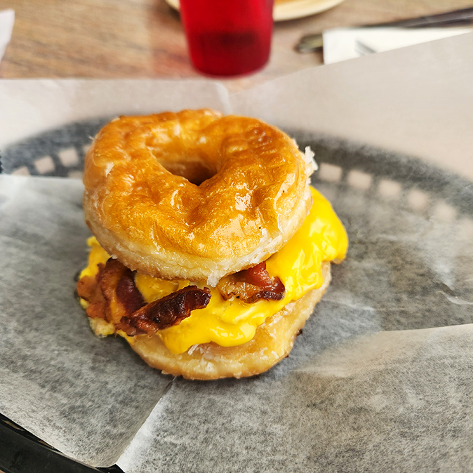 Breakfast architecture at its finest! A glazed donut embracing eggs, bacon and cheese&mdash;proof that sometimes the best ideas happen outside the toast box.