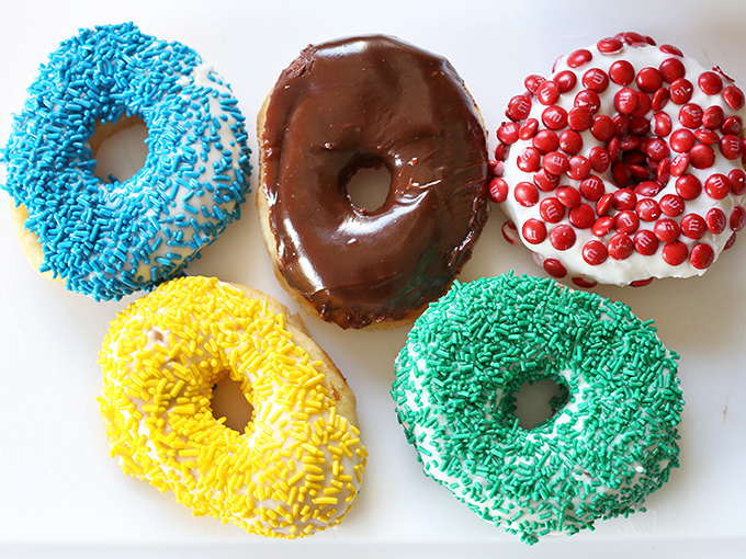 A rainbow of sprinkled perfection. These aren't just donuts; they're edible art that happens to pair perfectly with coffee.