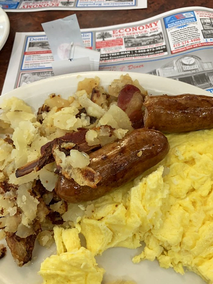 Breakfast perfection on a plate: fluffy scrambled eggs, sausage links with that satisfying snap, and home fries crispy enough to make a potato proud.