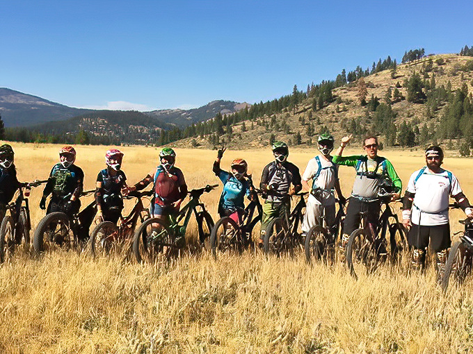 Mountain biking squads assemble in golden meadows beneath Sierra peaks – like a superhero team whose powers include conquering trails and appreciating panoramic views.