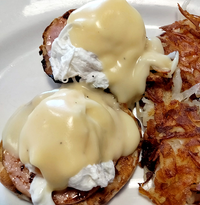 Behold the star attraction: Eggs Benedict with hollandaise cascading down like a buttery waterfall. This is breakfast architecture at its finest.