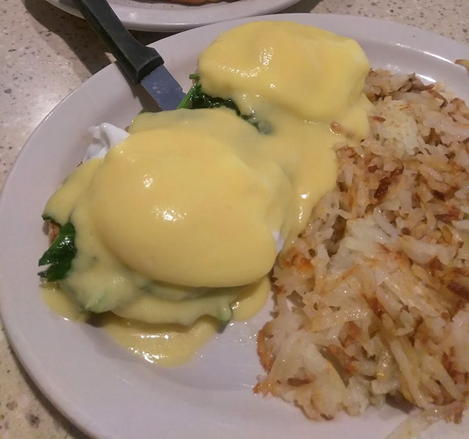 Behold the star attraction: Eggs Benedict draped in sunshine-yellow hollandaise, with hash browns crisped to golden perfection.