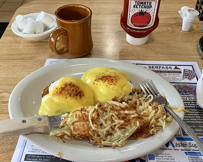 Behold, the holy grail of breakfast! Golden hollandaise cascading over perfectly poached eggs, served with crispy hash browns that demand to be devoured.