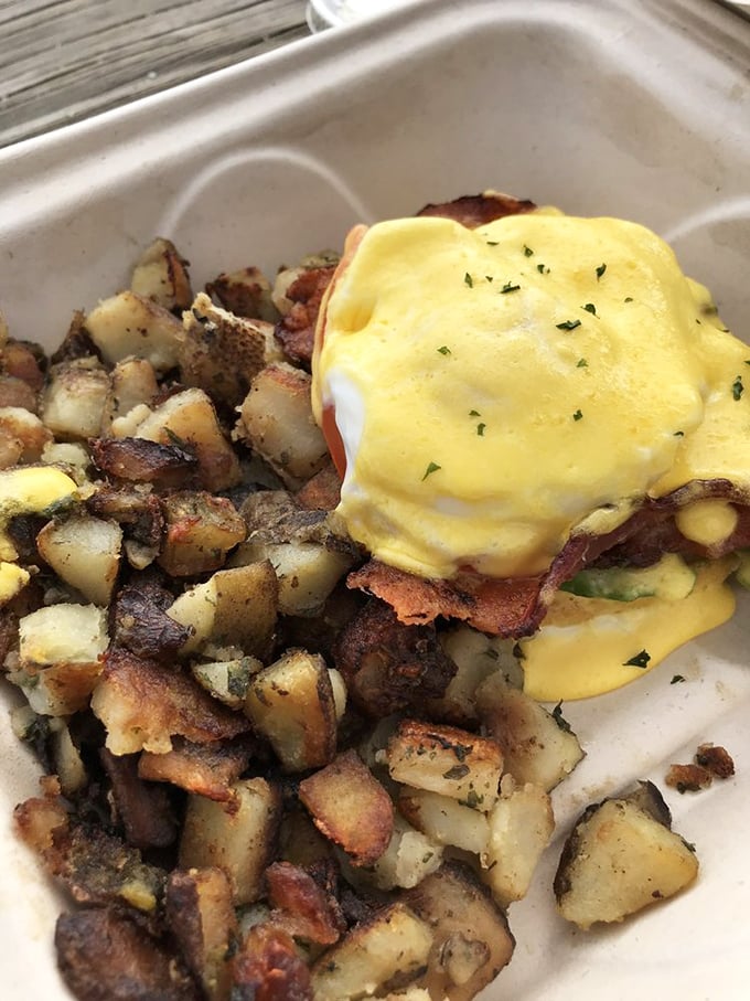Behold the Benedict in its natural habitat&mdash;golden hollandaise cascading over perfectly poached eggs, surrounded by home fries that deserve their own fan club.