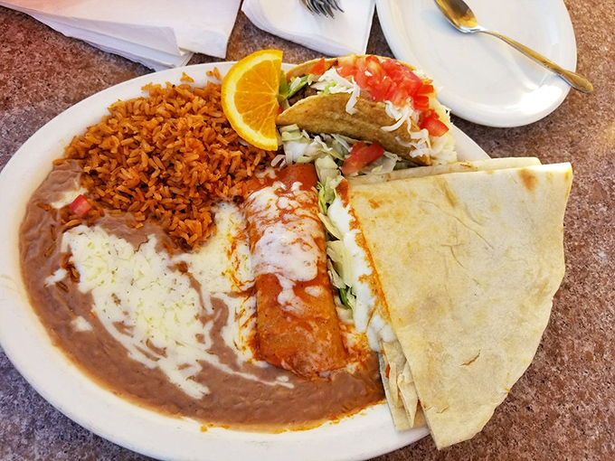 Behold the star of the show: an enchilada bathed in rich sauce alongside perfectly executed rice and beans. Simple? Yes. Ordinary? Not even close.