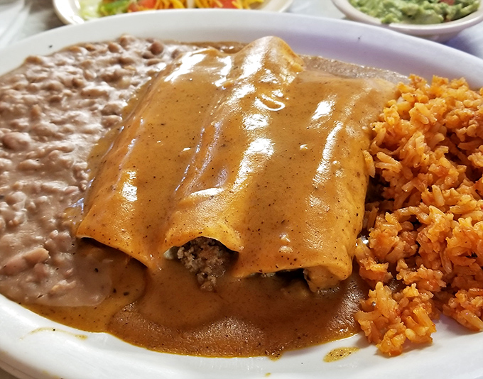 Enchiladas bathed in that perfect amber sauce – where the tortilla, filling, and sauce achieve the holy trinity of Tex-Mex perfection.