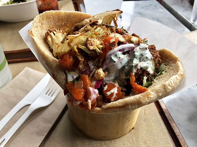 This isn't just a falafel sandwich; it's an architectural masterpiece of crispy, creamy, crunchy, and tangy elements. The Guggenheim of handheld meals.