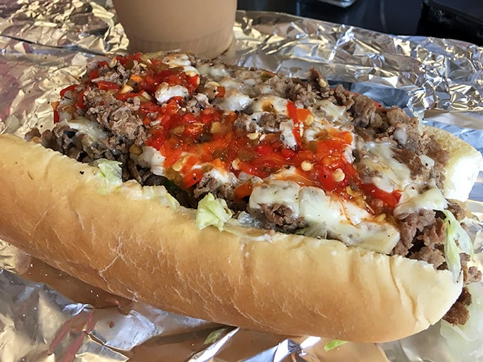 Behold the legendary Pounder Cheesesteak in all its glory—where melted cheese cascades over seasoned meat like a delicious lava flow. Dreams are made of this.