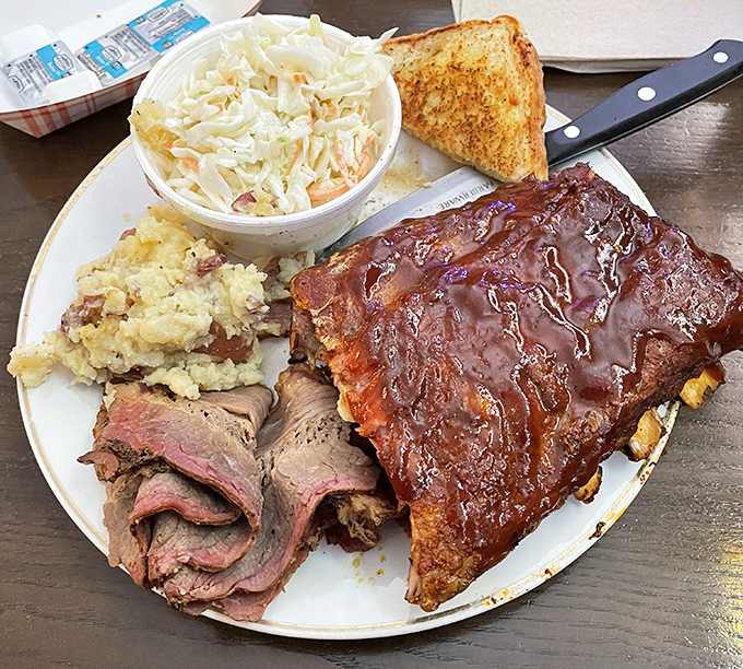 BBQ nirvana on a plate: ribs with that perfect pink smoke ring, brisket sliced just right, and sides that refuse to be mere afterthoughts.