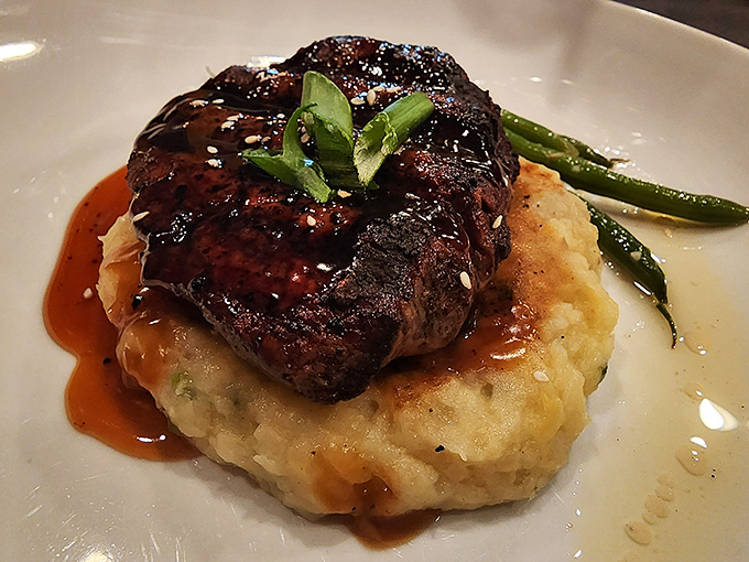 A perfectly seared filet mignon resting on a cloud of mashed potatoes &ndash; proof that sometimes the simplest pleasures are the most profound.