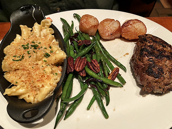 A perfect trifecta: mac and cheese with a golden crust, green beans with pecans, and a steak with grill marks that deserve their own Instagram account.