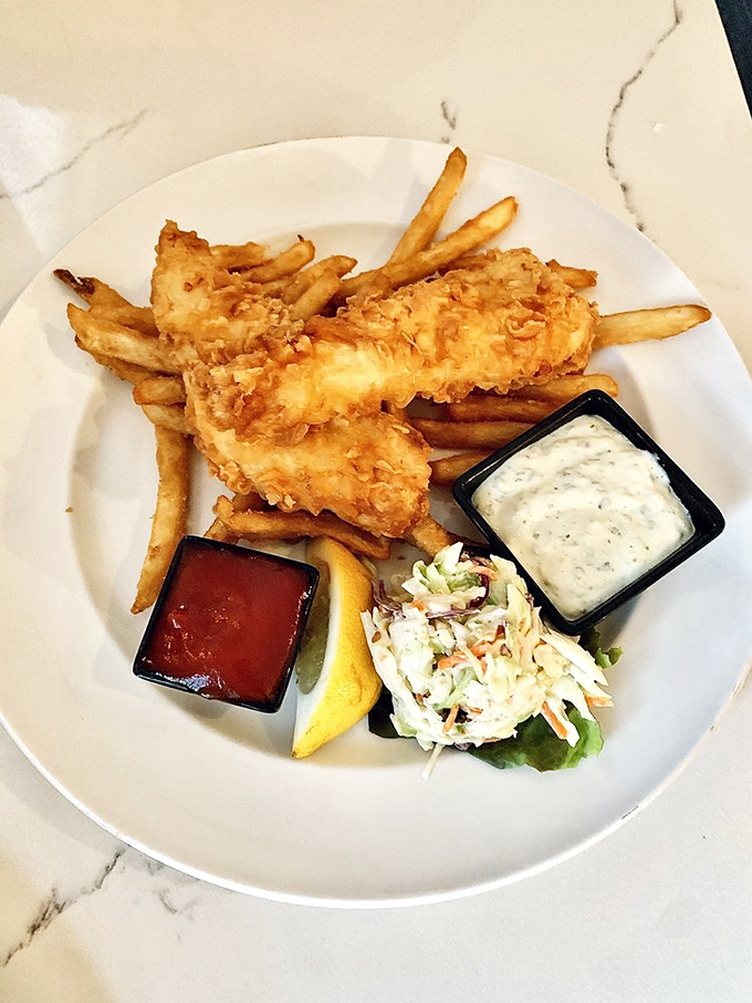 Fish and chips done right—golden-battered fish that shatters like glass at the touch of a fork, paired with hand-cut fries. Diet plans, officially postponed.