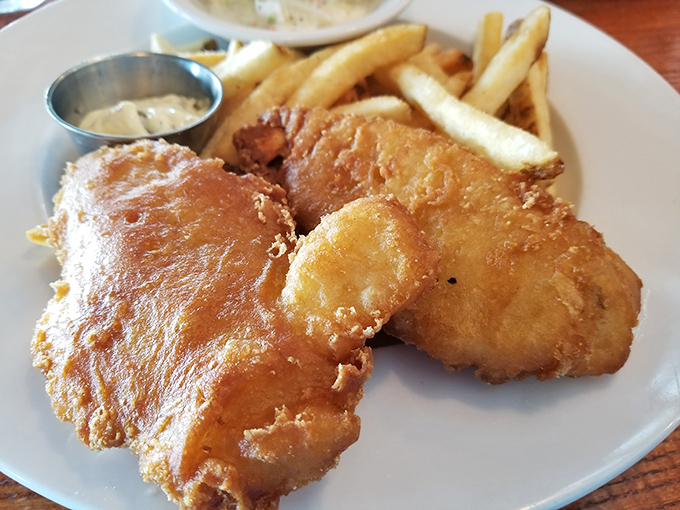 Golden-battered fish that shatters at first bite, revealing flaky perfection beneath &ndash; this is what fish and chips dreams are made of.