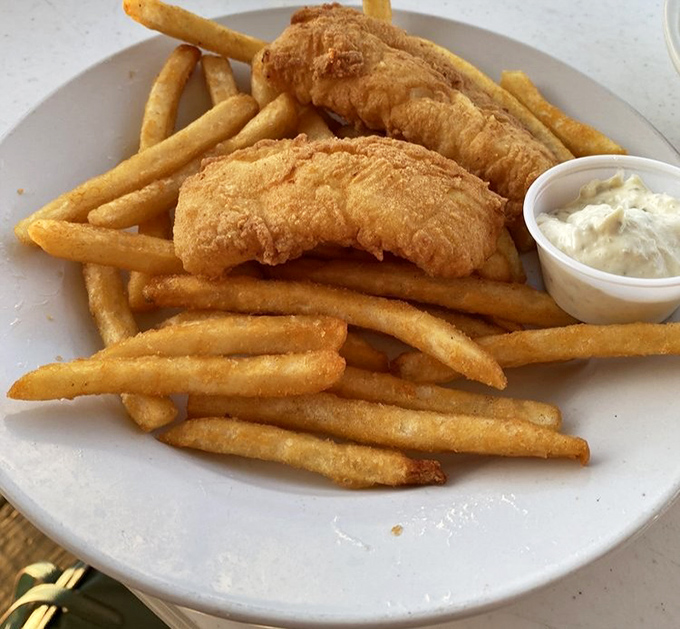 Golden-battered fish that shatters with each bite, alongside fries that deserve their own fan club. This isn't just fish and chips&mdash;it's edible sunshine.
