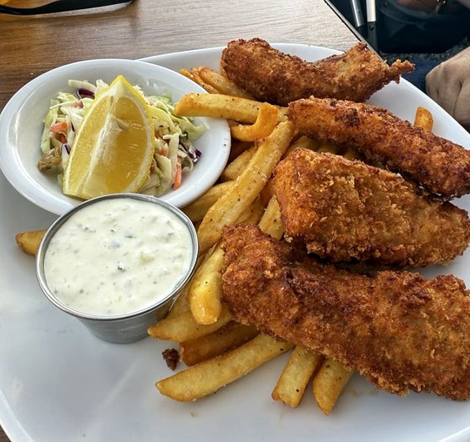 Golden-battered fish that shatters with each bite, alongside fries that actually deserve to share the plate. This is why you came.
