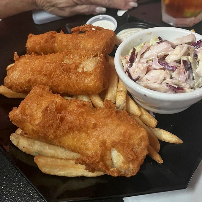 Golden-battered fish that shatters with each bite, alongside crispy fries and creamy slaw&mdash;the holy trinity of diner perfection.