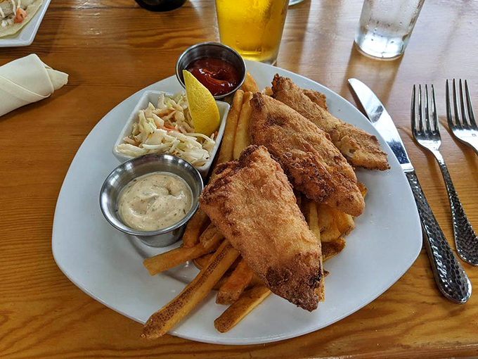 Golden-battered fish perches atop a mountain of fries like the catch of the day showing off its Sunday best.