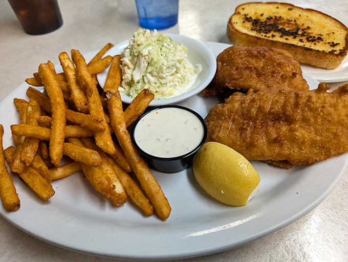 Golden-battered fish with a perfect crunch factor, served alongside crispy fries, coleslaw, and tartar sauce&mdash;this is what fish and chips dreams are made of.