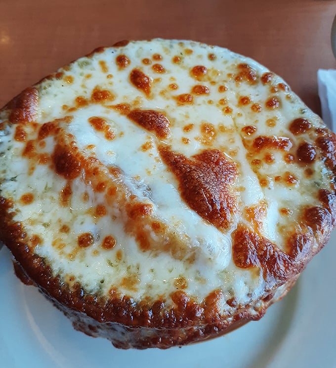 This isn't just cheese on soup&mdash;it's a golden-brown cathedral dome of bubbling perfection that demands a moment of reverent silence before diving in.