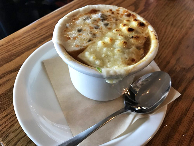 Behold the legendary French onion soup in all its glory&mdash;a bubbling cauldron of caramelized perfection beneath a golden cheese canopy that stretches like a dream.
