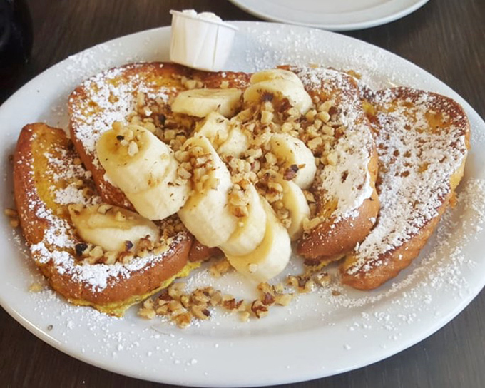 French toast nirvana! Golden slices adorned with bananas, walnuts, and a dusting of powdered sugar&mdash;proof that breakfast can indeed be the most important art of the day.