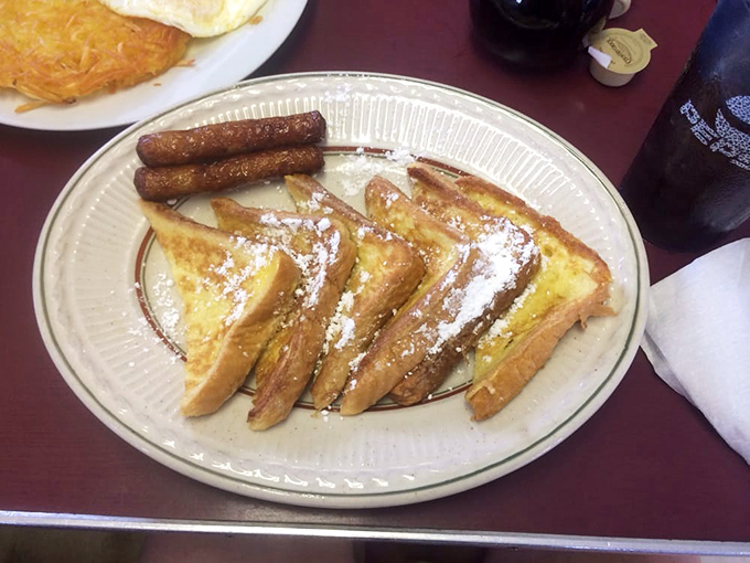 French toast perfection! Golden-brown slices dusted with powdered sugar and served with sausage links &ndash; breakfast doesn't get more beautiful than this.