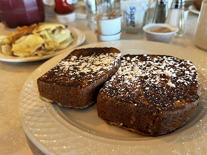 This French toast doesn't just arrive at your table &ndash; it makes an entrance, dusted with powdered sugar like fresh snow on Christmas morning. 
