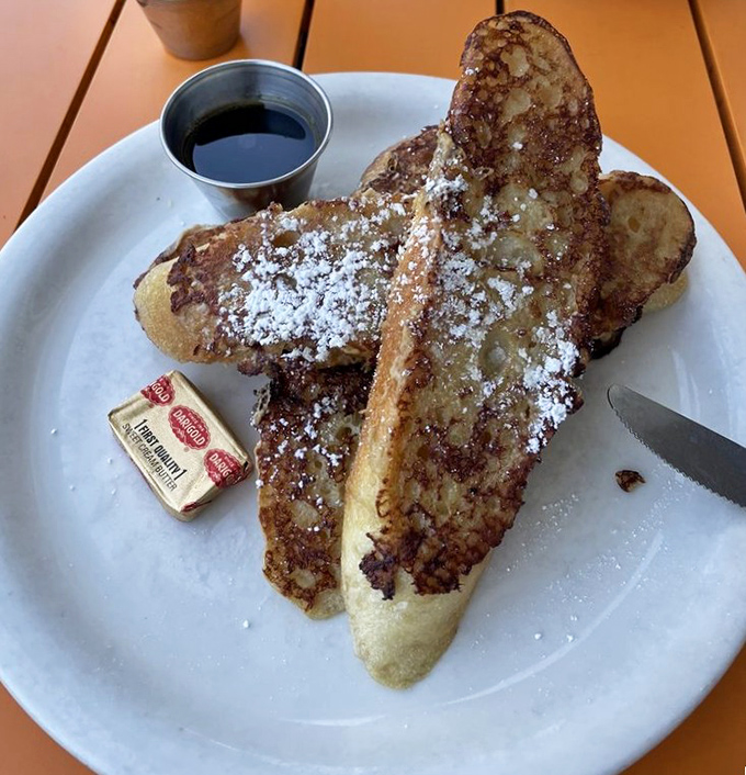 Behold the French toast that launches a thousand road trips &ndash; thick, golden, and dusted with powdered sugar perfection.