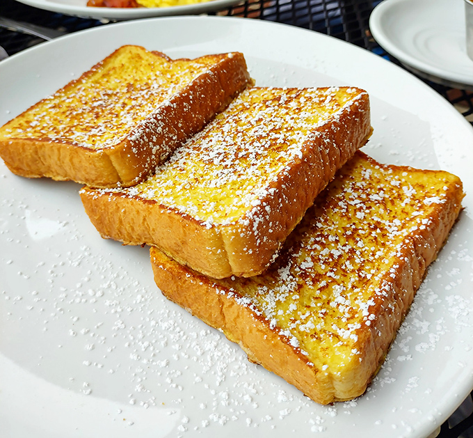 Golden French toast dusted with powdered sugar that makes every morning feel like Sunday. Three perfect slices of bread that took a luxurious bath in egg.