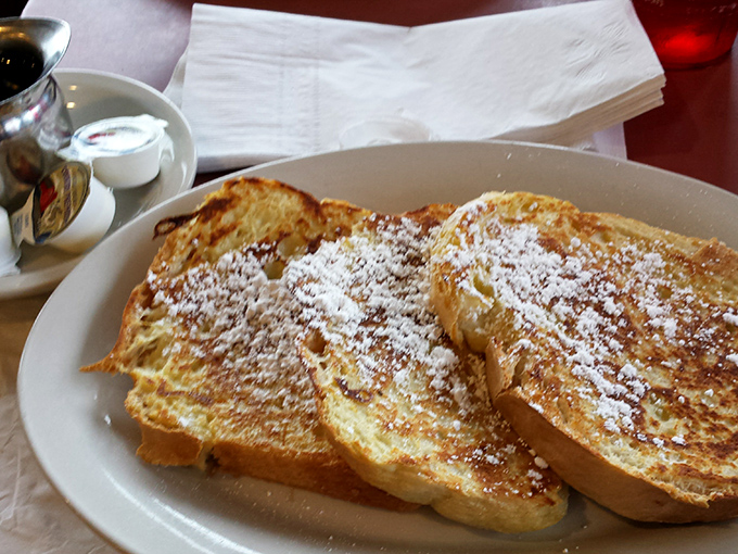French toast that transforms ordinary bread into something transcendent—crisp edges giving way to custardy centers dusted with powdered sugar.