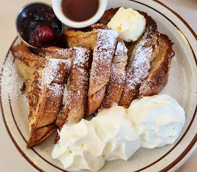 This isn't just French toast&mdash;it's a masterclass in breakfast architecture, complete with powdered sugar snowfall and whipped cream mountains.