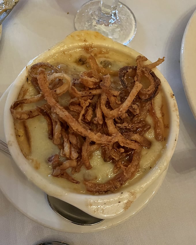 The legendary French onion soup arrives like a work of art &ndash; a bubbling cauldron of perfectly caramelized onions beneath a golden crown of cheese.