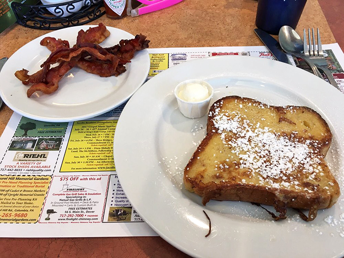 French toast that's achieved golden perfection, dusted with powdered sugar and served with bacon that's found that magical space between crispy and chewy.