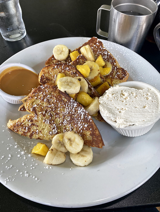 Behold the French toast that dreams are made of &ndash; golden triangles crowned with fresh fruit and powdered sugar perfection.