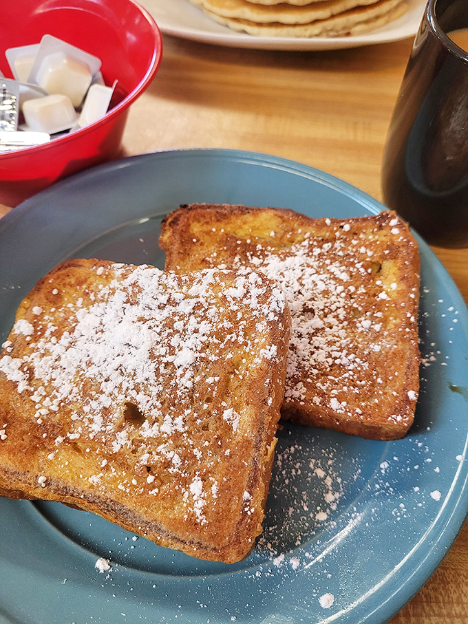 Golden-brown perfection on a blue plate. This French toast has that magical crispy exterior and custardy interior that breakfast fantasies are made of.