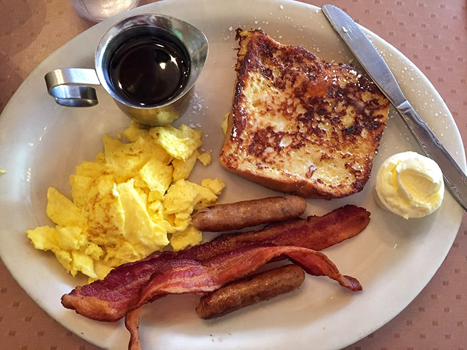 The legendary French toast combo &ndash; golden perfection flanked by eggs and bacon like delicious bodyguards protecting breakfast royalty.
