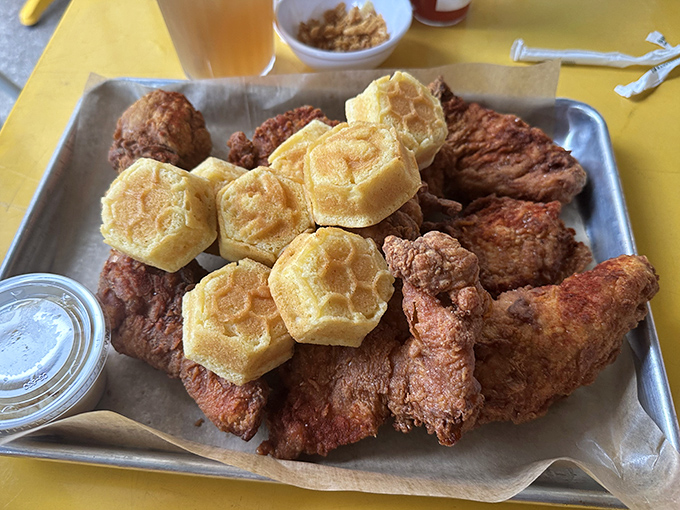 Golden-brown perfection meets honeycomb-shaped corn muffins. This tray of crispy, juicy chicken is what food photographers dream about at night.