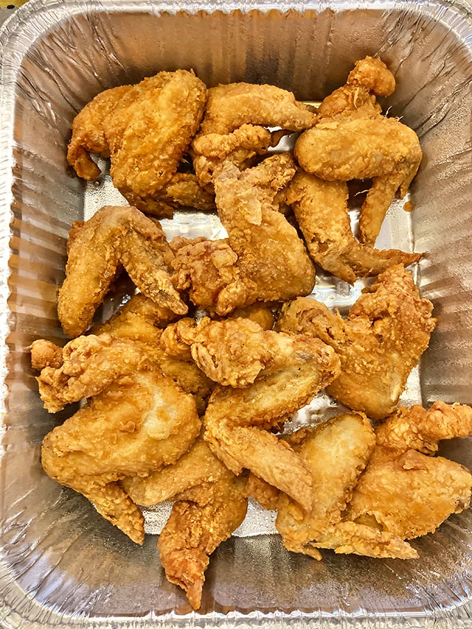 Golden-brown perfection in aluminum simplicity. This isn't just fried chicken&mdash;it's edible architecture with a PhD in crunchology.